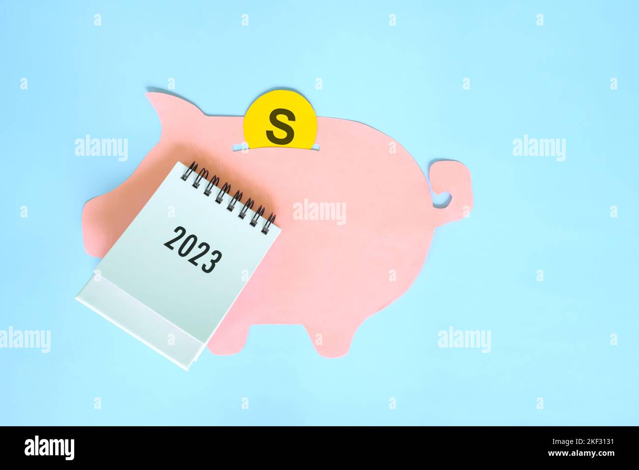 New year 2023 start saving resolution concept. Desk calendar with piggy ...