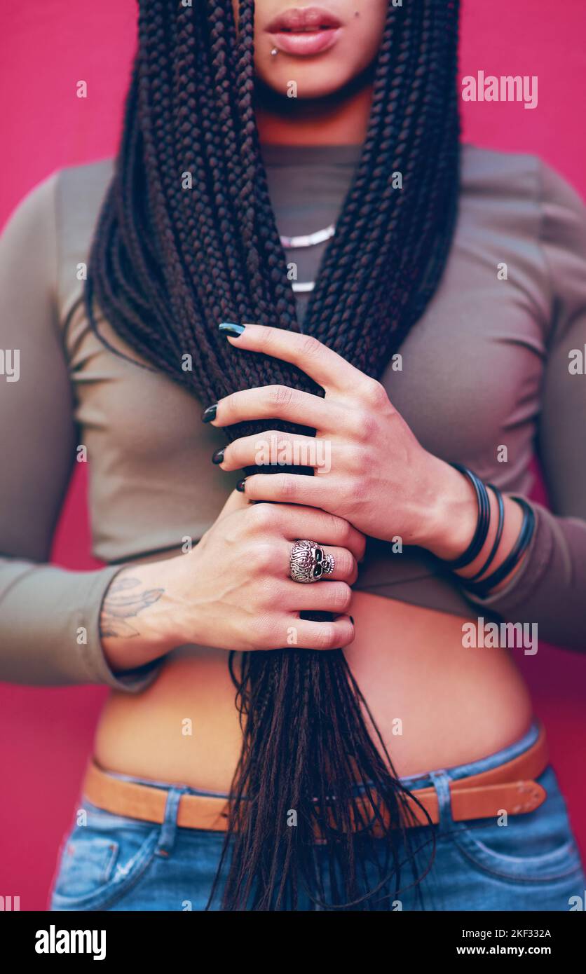 The beauty of braids. a young woman with braids posing against a pink ...