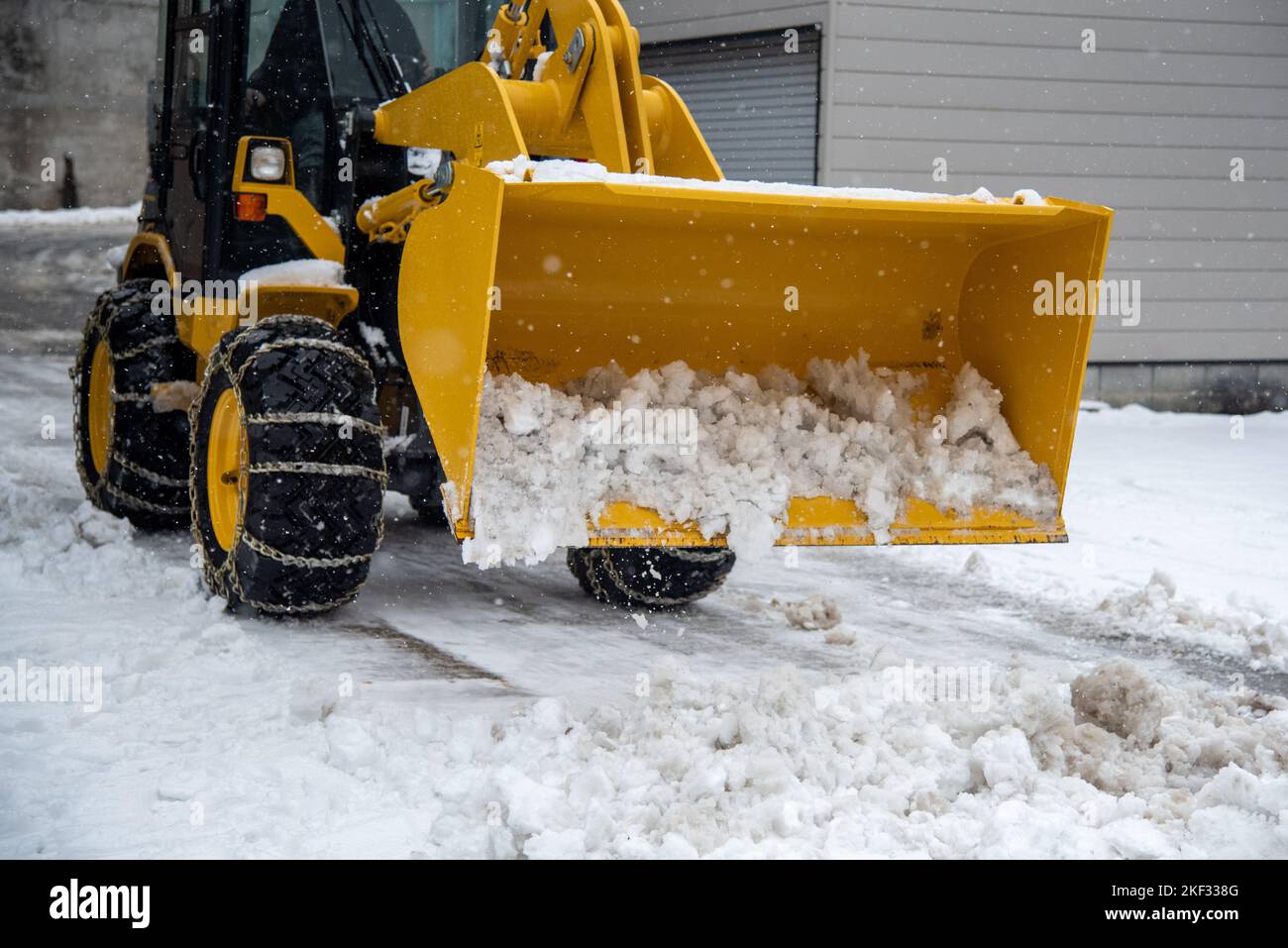 Tractor scoop with snow in the winter, Clearing snow after a storm ...