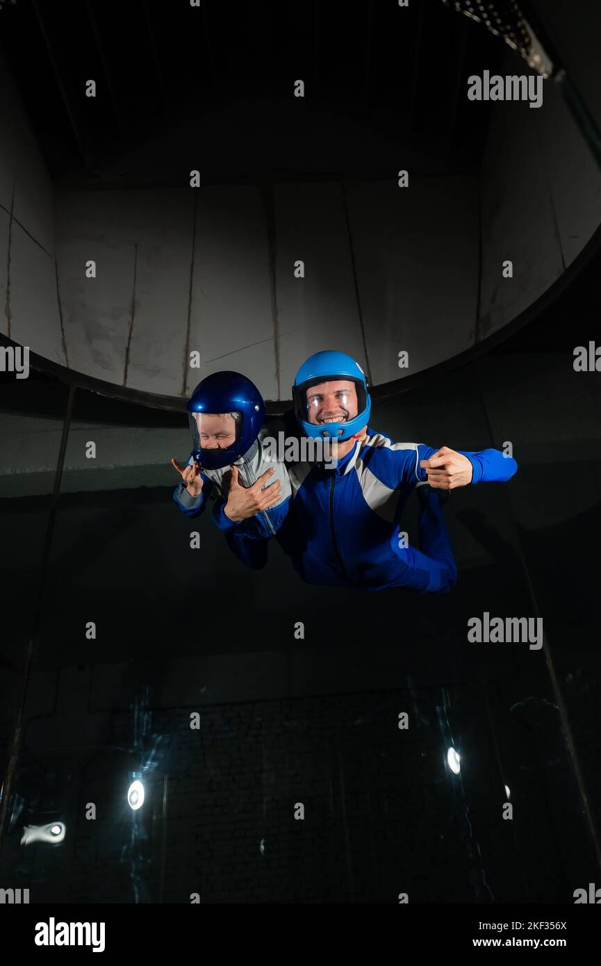 A man teaches a boy to fly in a wind tunnel. Lack of gravity Stock ...