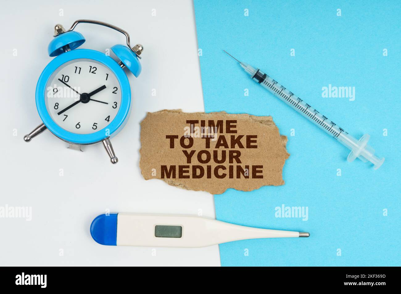 Medical concept. A clock, a thermometer, a syringe and a cardboard with ...