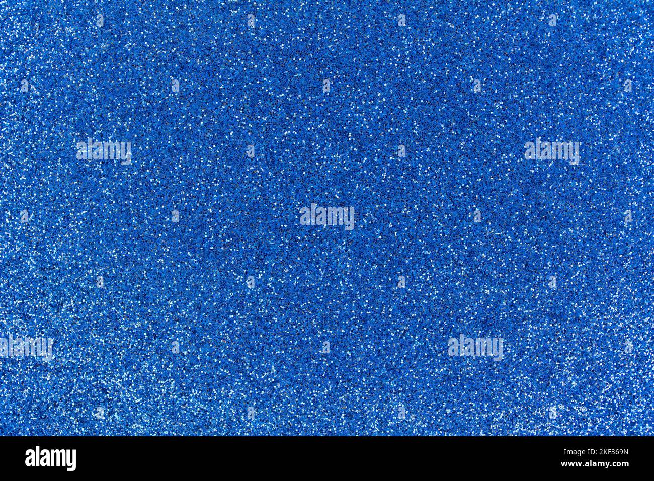 Full frame macro image of a deep blue color sparkling glitter texture ...