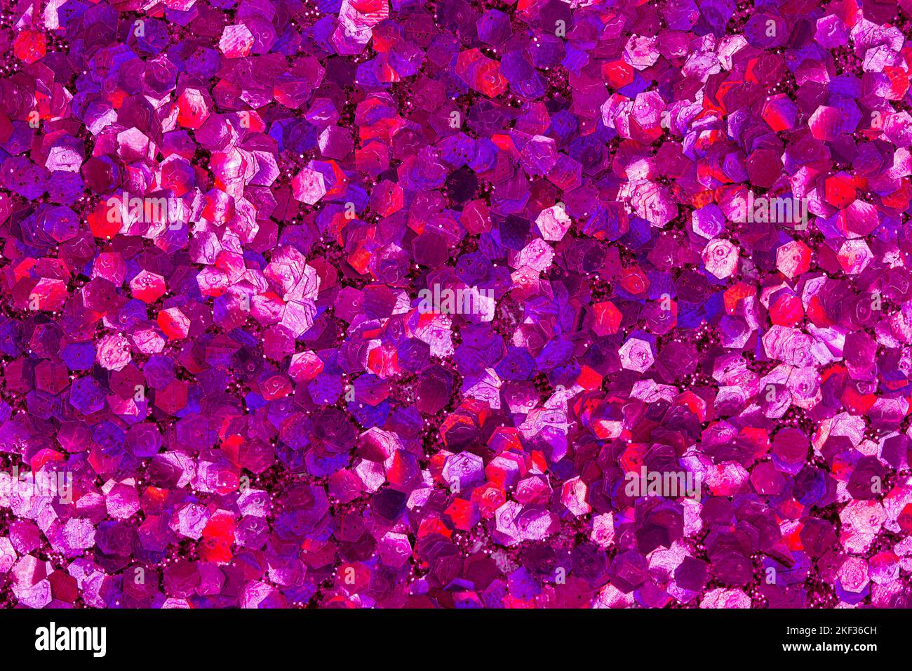 Full frame macro image of a rosy pink color sparkling glitter texture ...