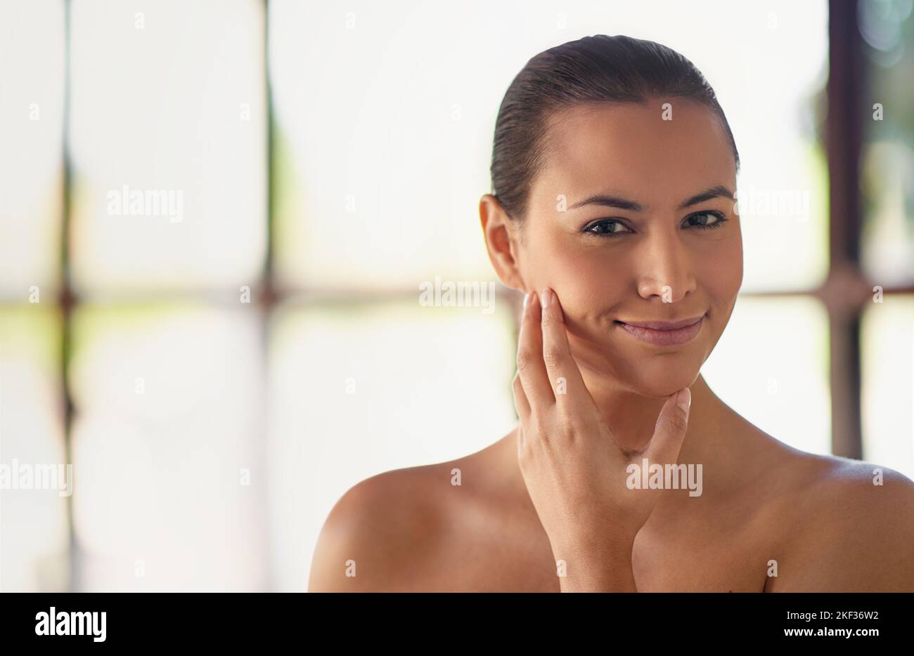 Loving her skin after that spa treatment. a young woman at the day spa ...