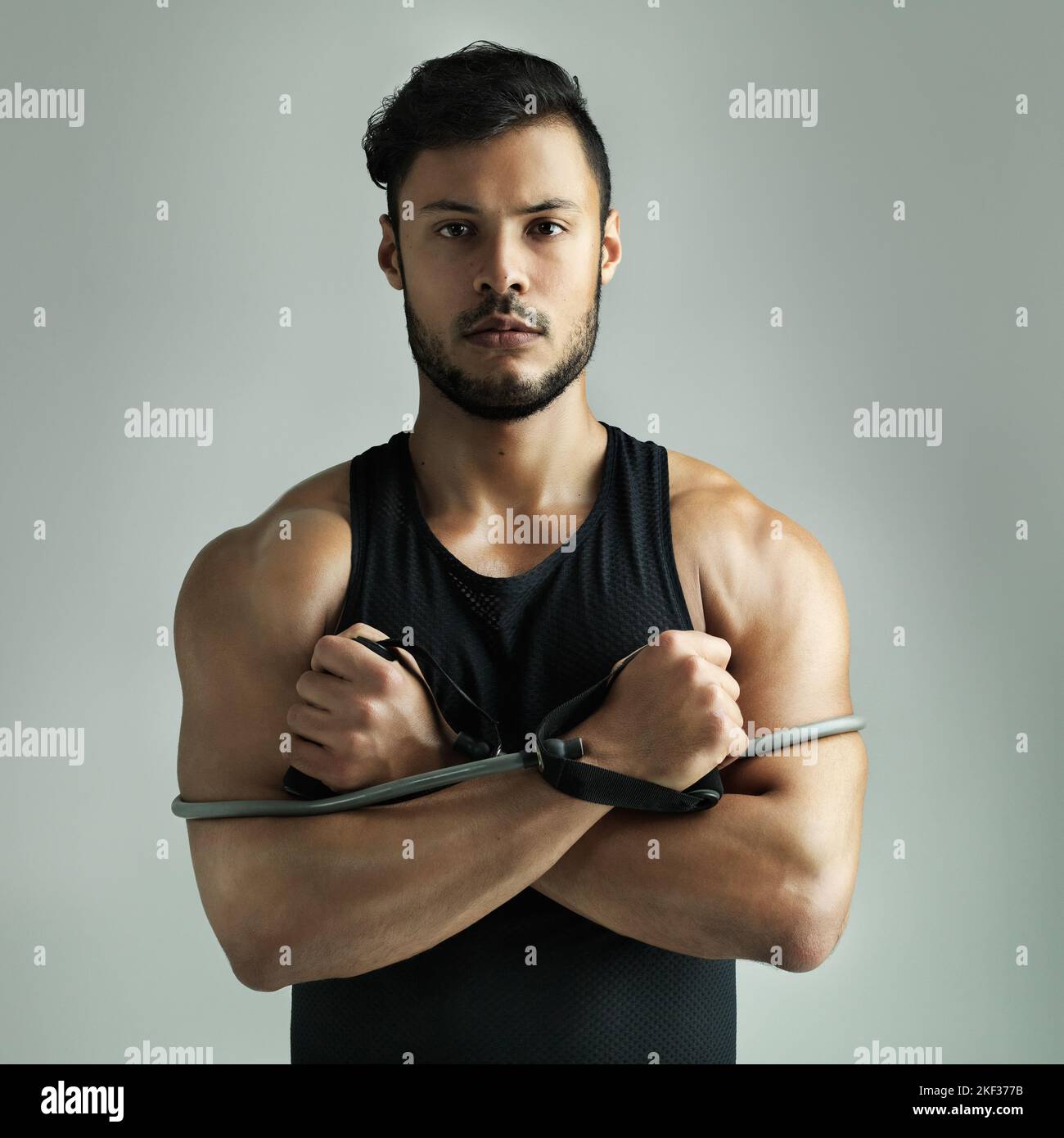 Ready for some resistance training. Studio shot of a young man working ...
