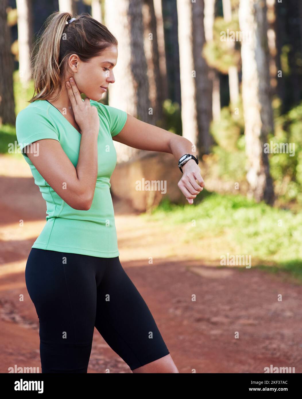 Steadily improving her fitness levels. a young woman checking her heart ...