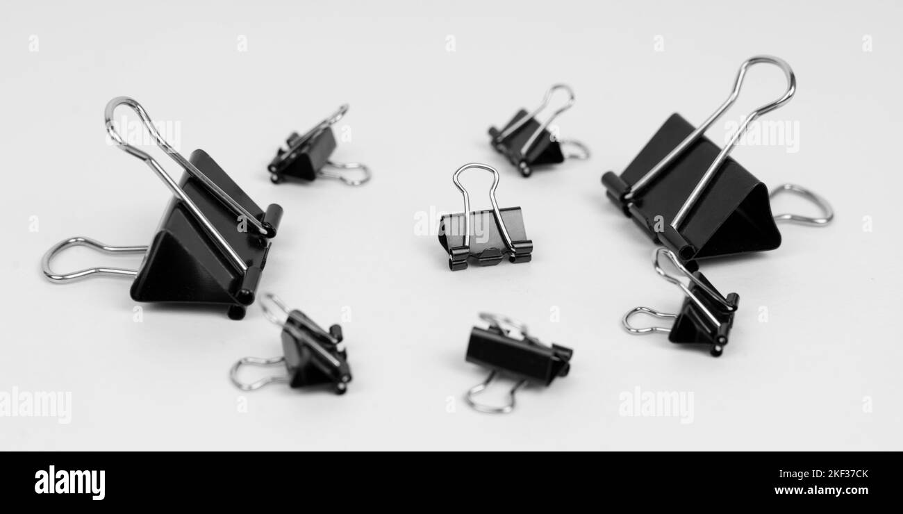Office. Black clips of different sizes are on a white background Stock ...