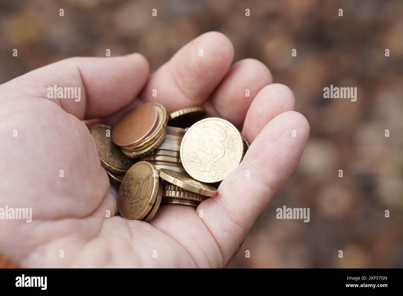 Economy and business concept. The man has a handful of coins in his ...