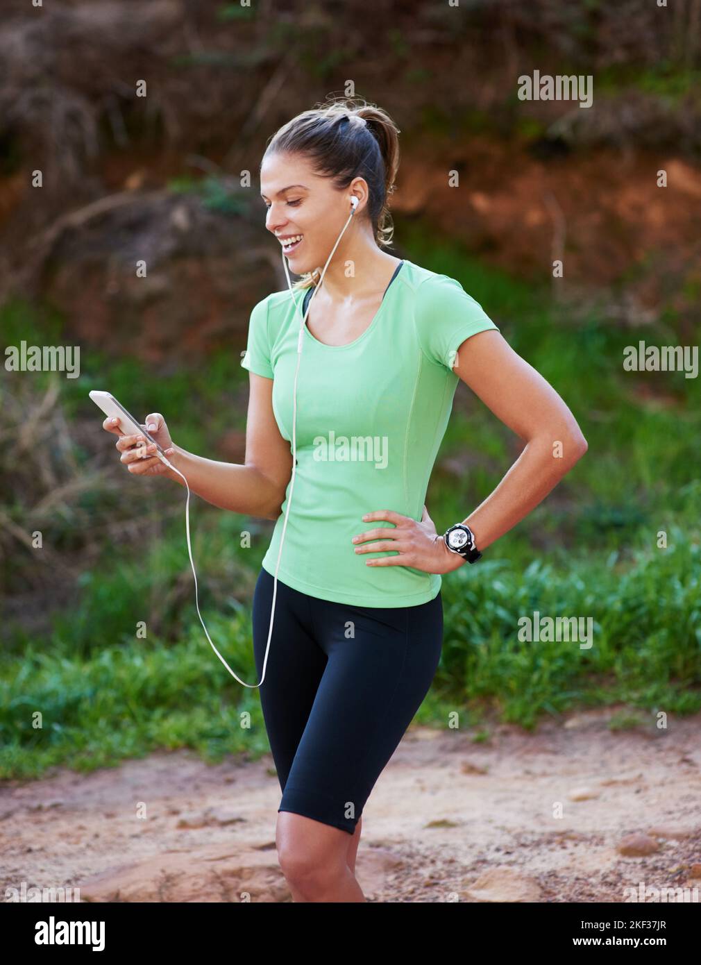 Choosing music that will motivate her on the run. a young woman ...