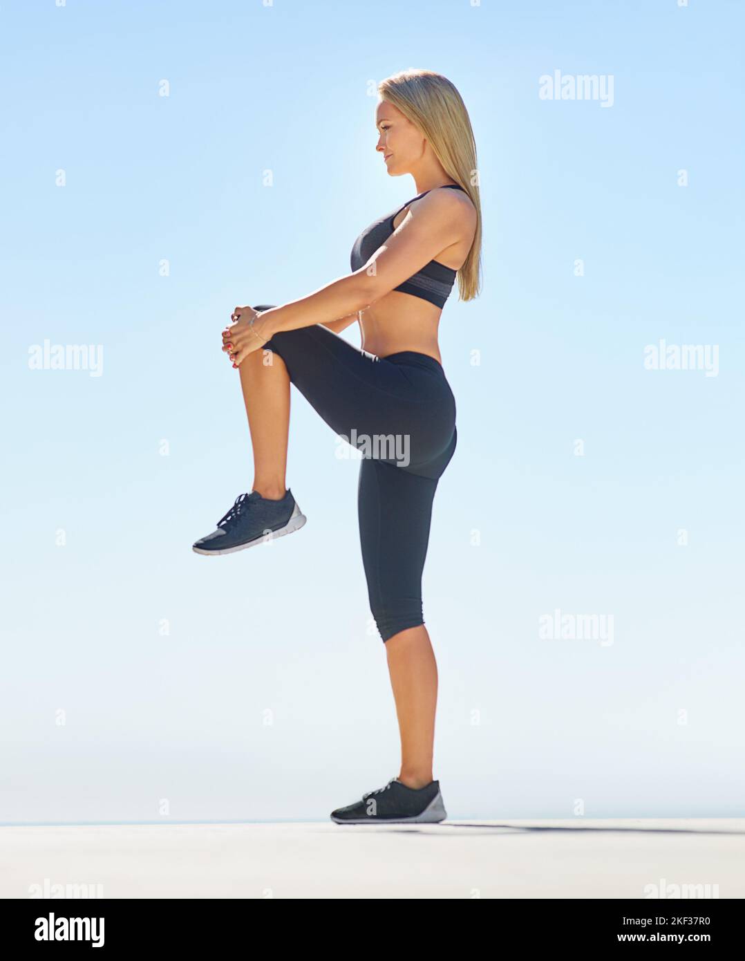 Stretch it out. Full length shot of a young woman stretching her legs outside Stock Photo - Alamy