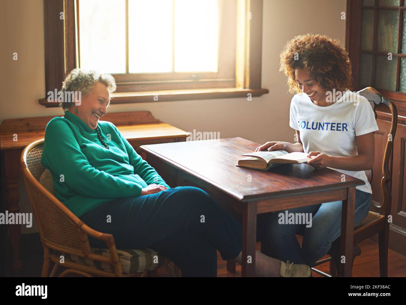Bringing happiness through reading. a volunteer reading to a senior ...