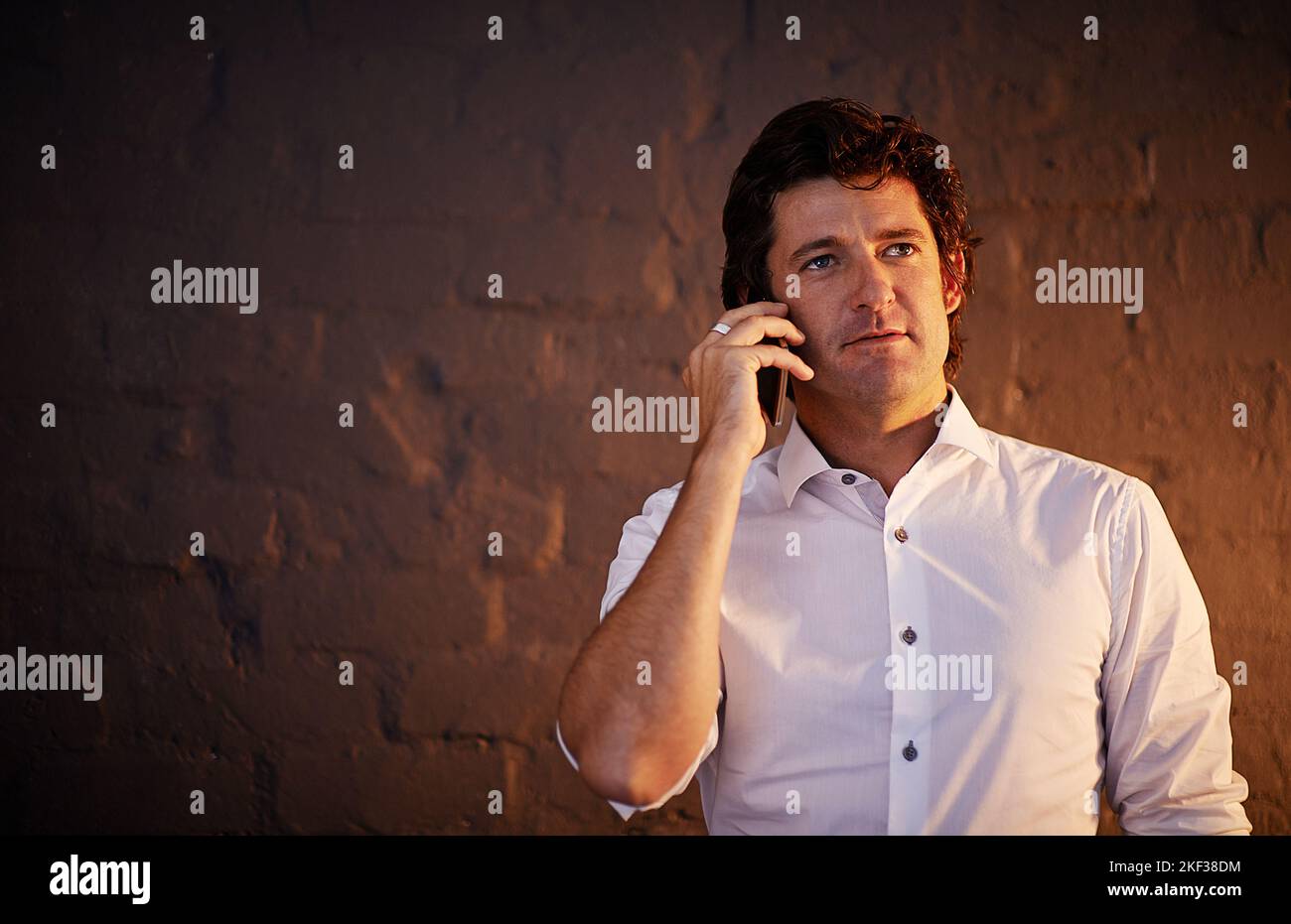 Closing a crucial deal. a businessman making a phone call after hours ...