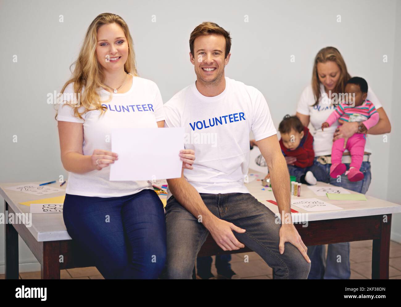 We love giving back to the community. volunteers holding up a blank ...