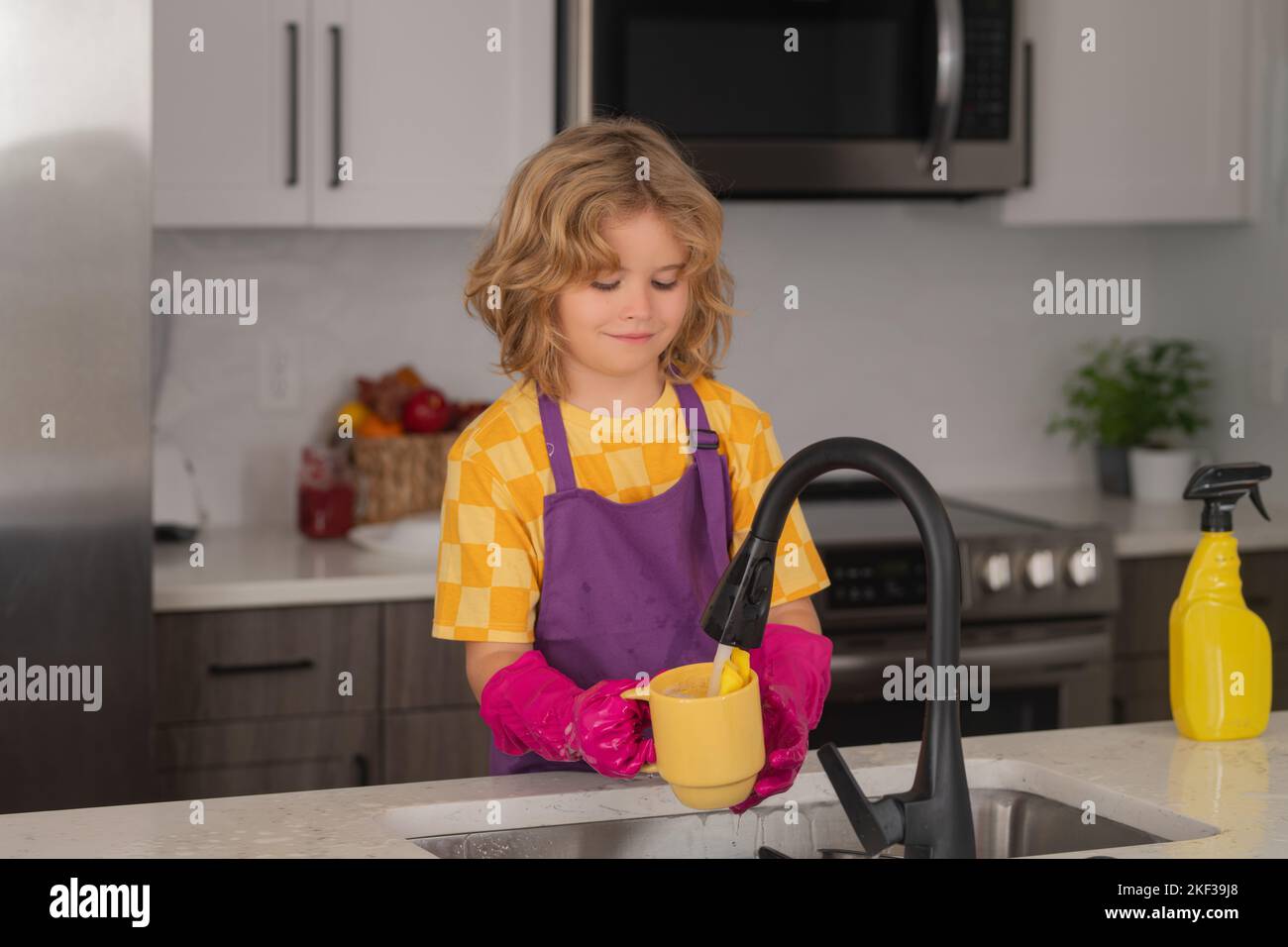 Kid housekeeper. Child washing and wiping dishes in kitchen. American ...