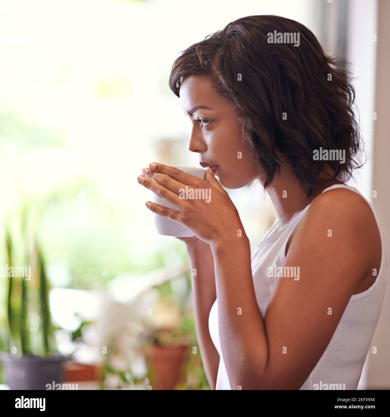 Quiet contemplation over coffee. a young woman drinking a beverage at ...