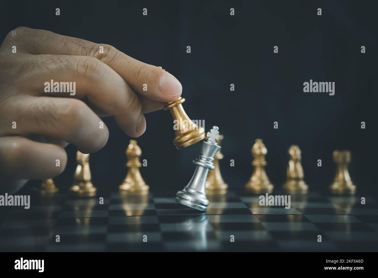 Businessman hand moving gold chess king figure and checkmate opponent ...