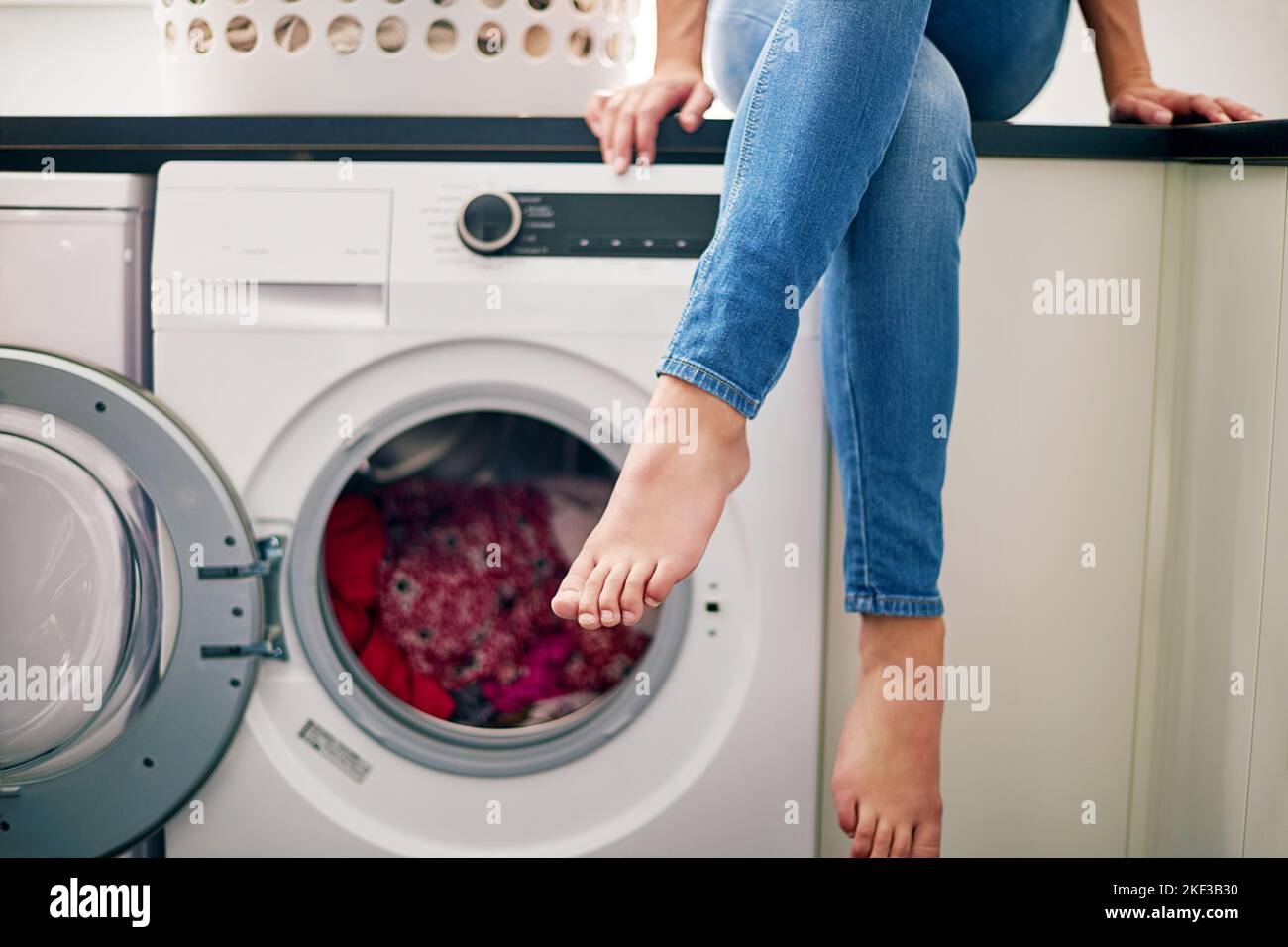 Its laundry day. young woman doing laundry at home Stock Photo - Alamy
