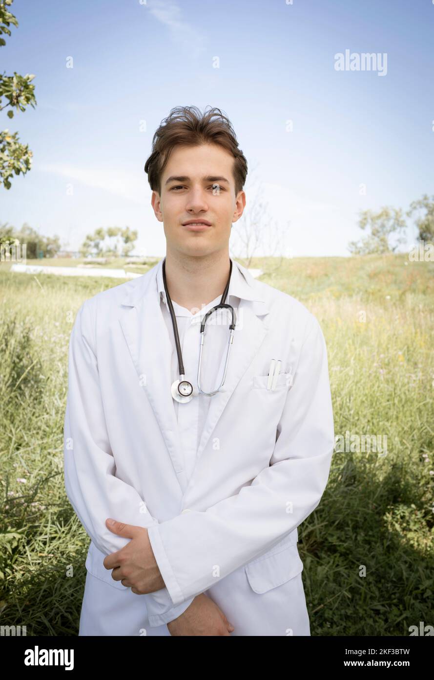 young sympathetic doctor with white coat and stethoscope around his ...
