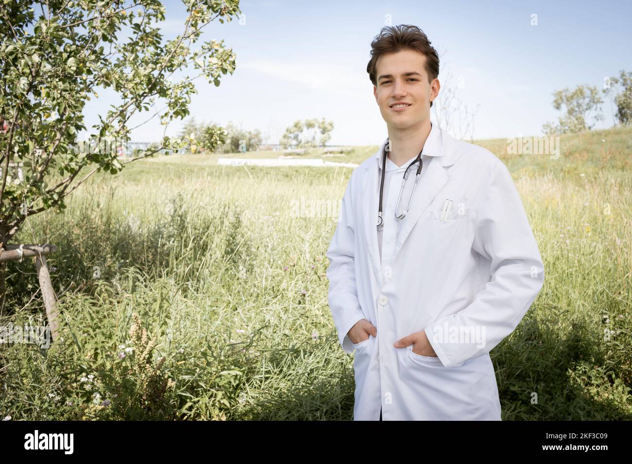 young sympathetic doctor with white coat and stethoscope around his ...