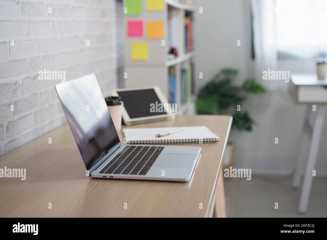 Close up view of worktable with laptop or computer, tablet, notebook ...