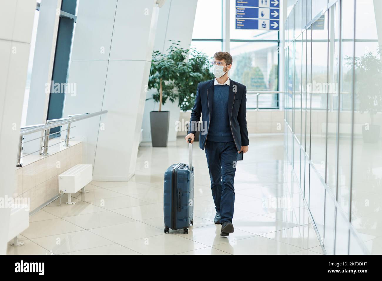 passenger in a protective mask walking in the airport building Stock ...
