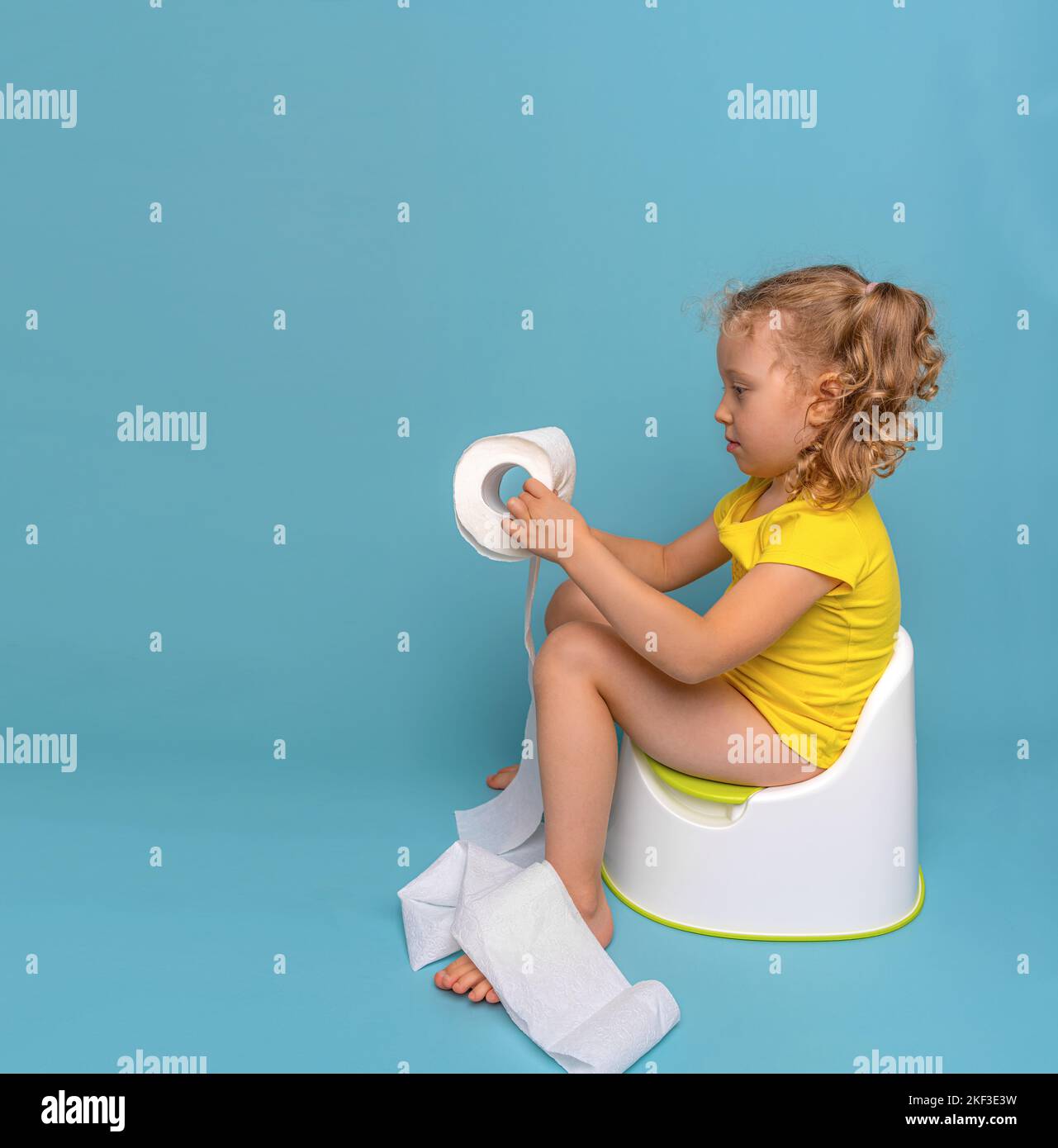 A child on the potty plays with toilet paper Stock Photo - Alamy