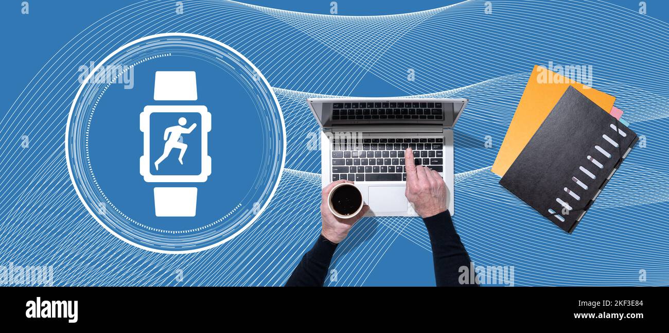 Top view of hands using laptop with symbol of wearable technology ...