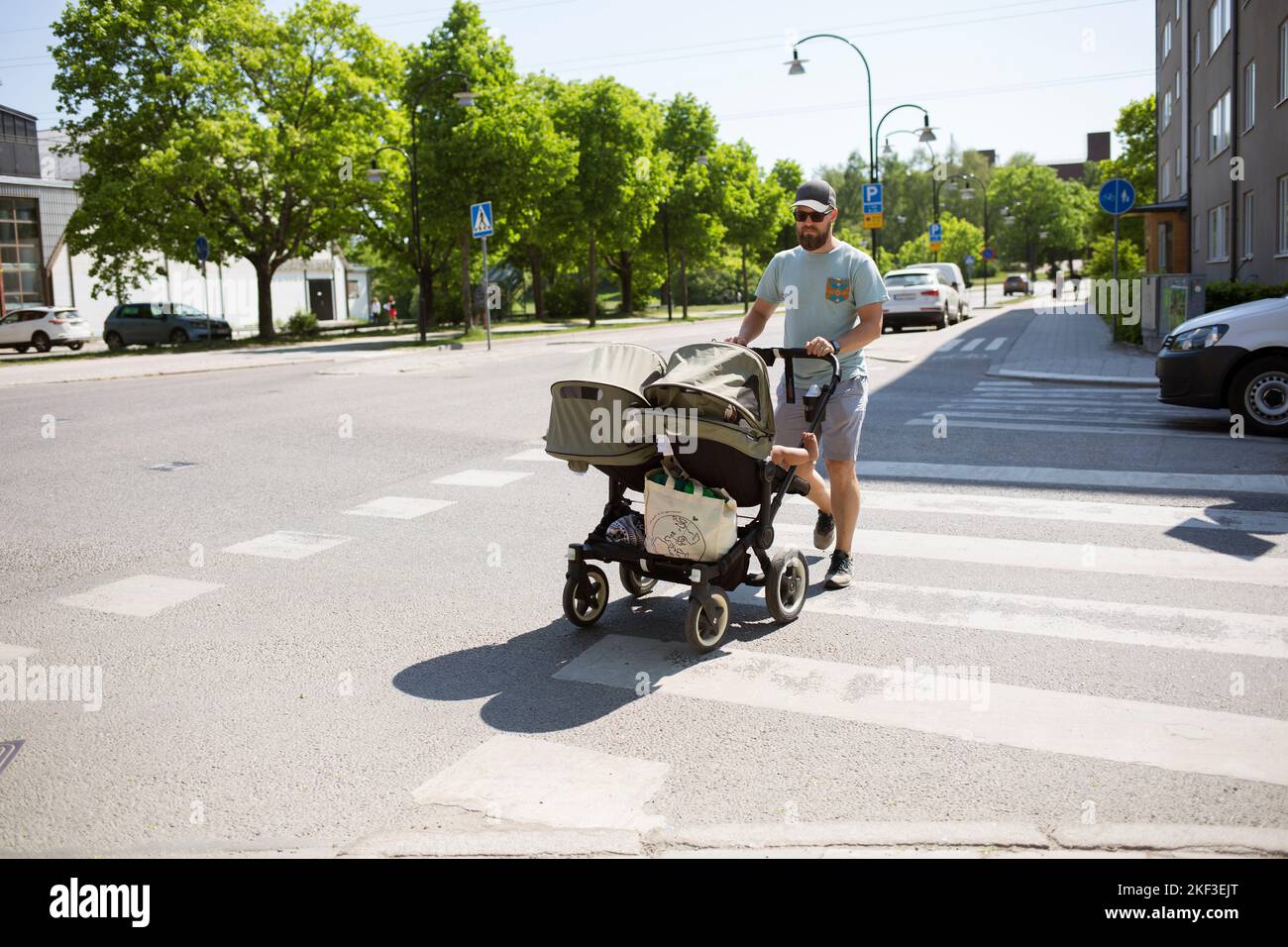 Man walking with stroller on street Stock Photo - Alamy