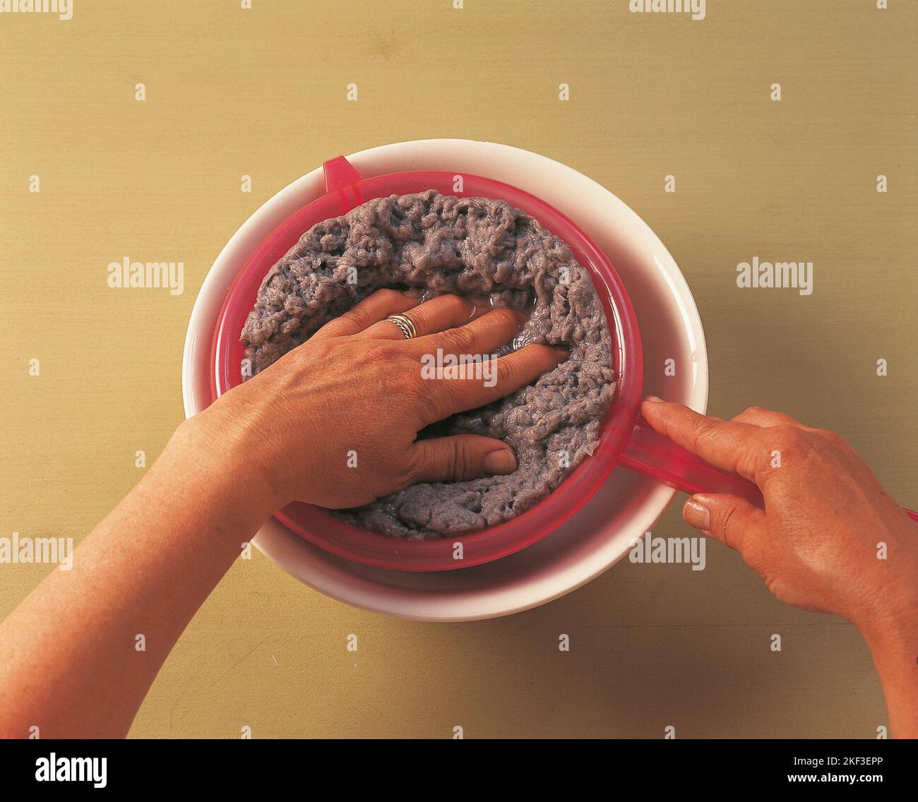 Pressing the pulp down into the sieve Stock Photo - Alamy