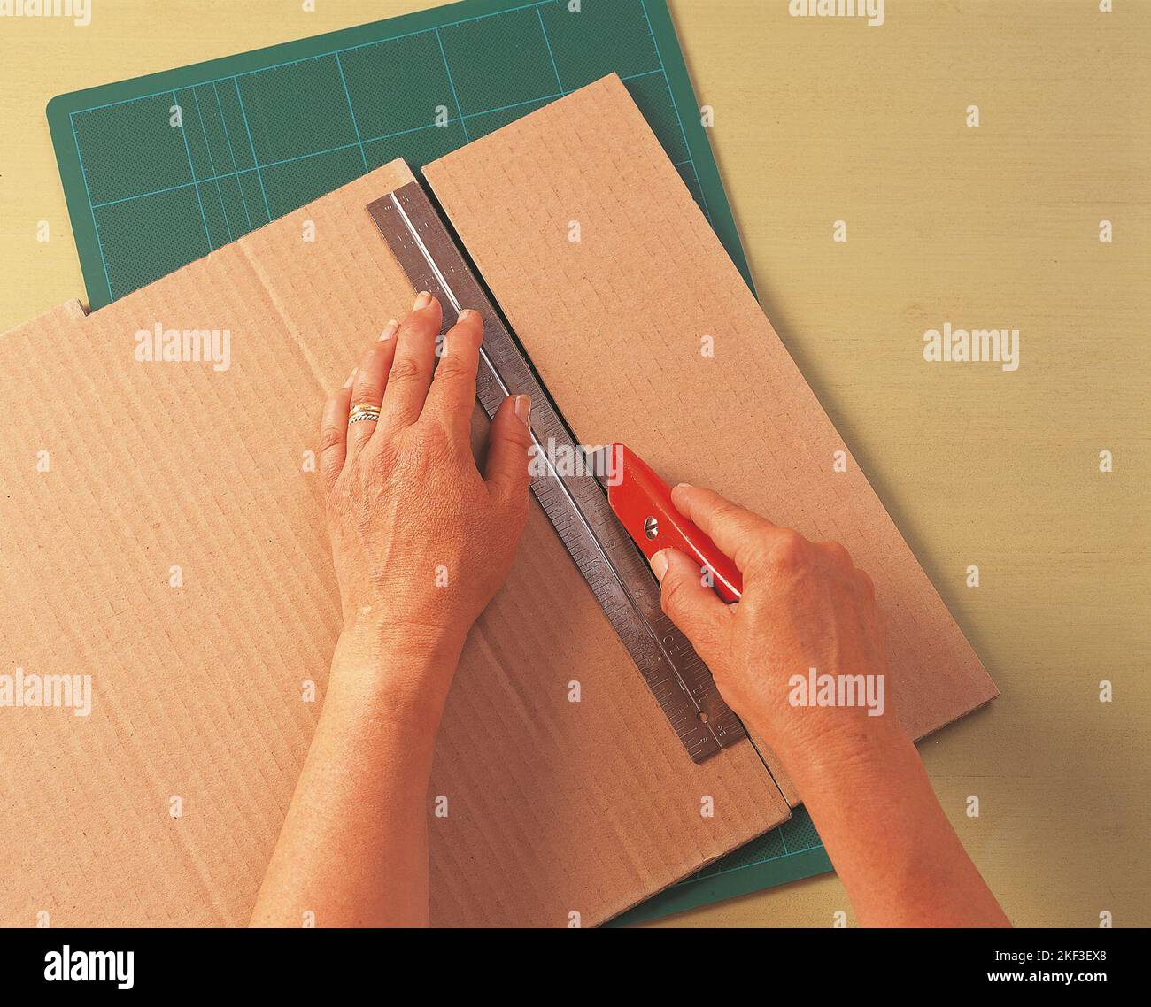 Cutting the corrugated cardboard with utility knife Stock Photo - Alamy