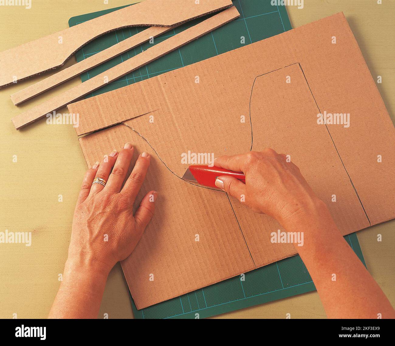 Cutting the corrugated cardboard with utility knife Stock Photo - Alamy