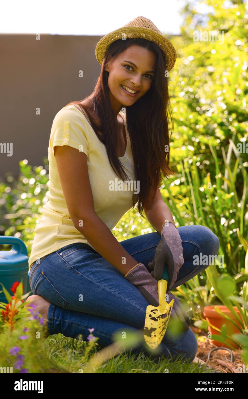 Woman, garden and portrait of gardener using a shovel for landscaping ...