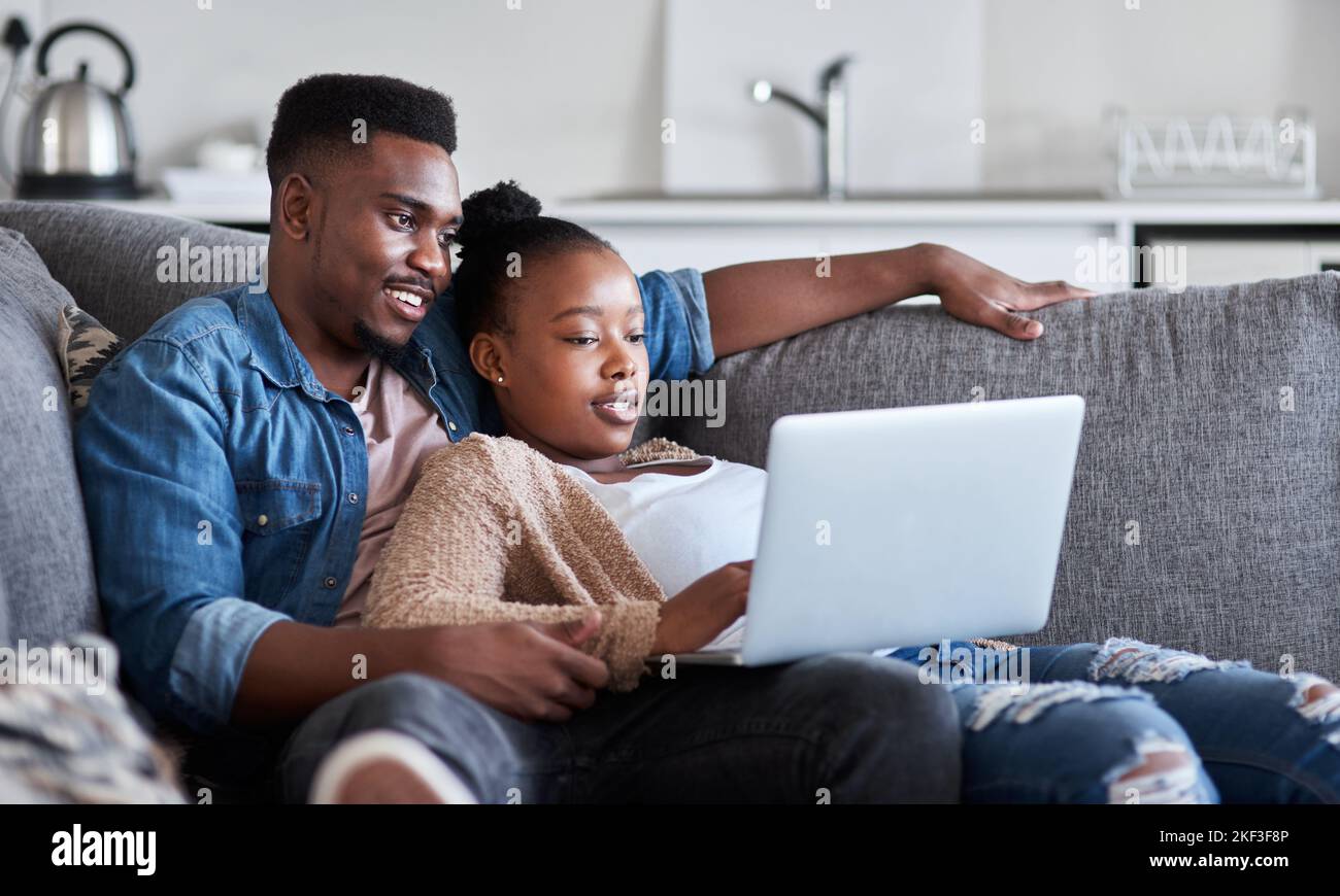 Black couple, laptop and living room sofa to relax while streaming ...