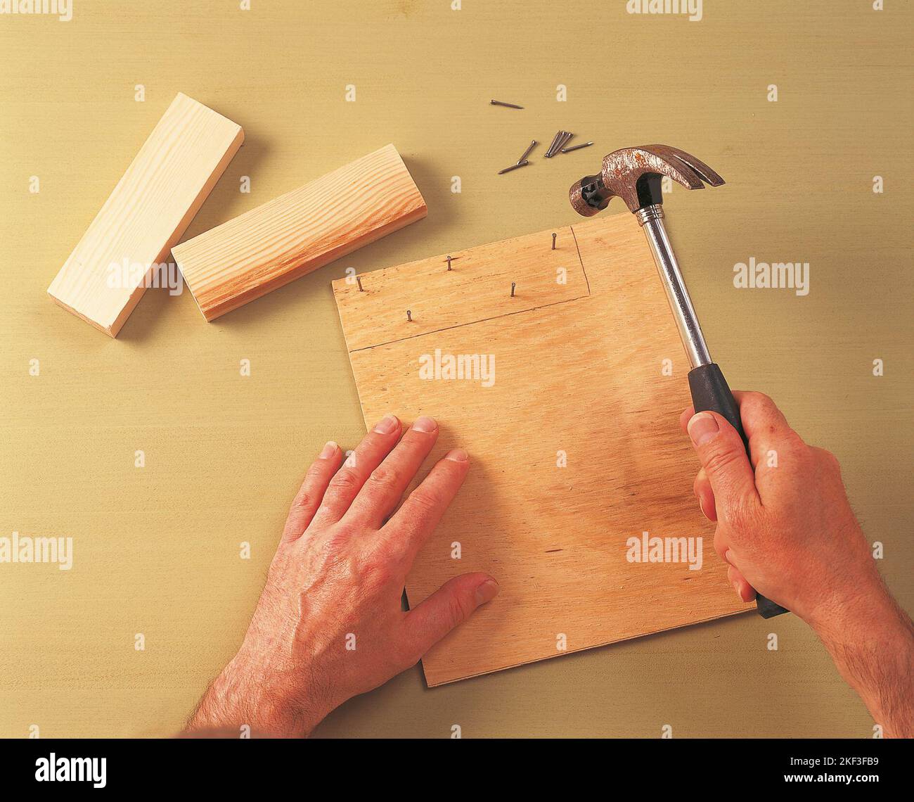Knocking a pin to one side of the chipboard Stock Photo - Alamy