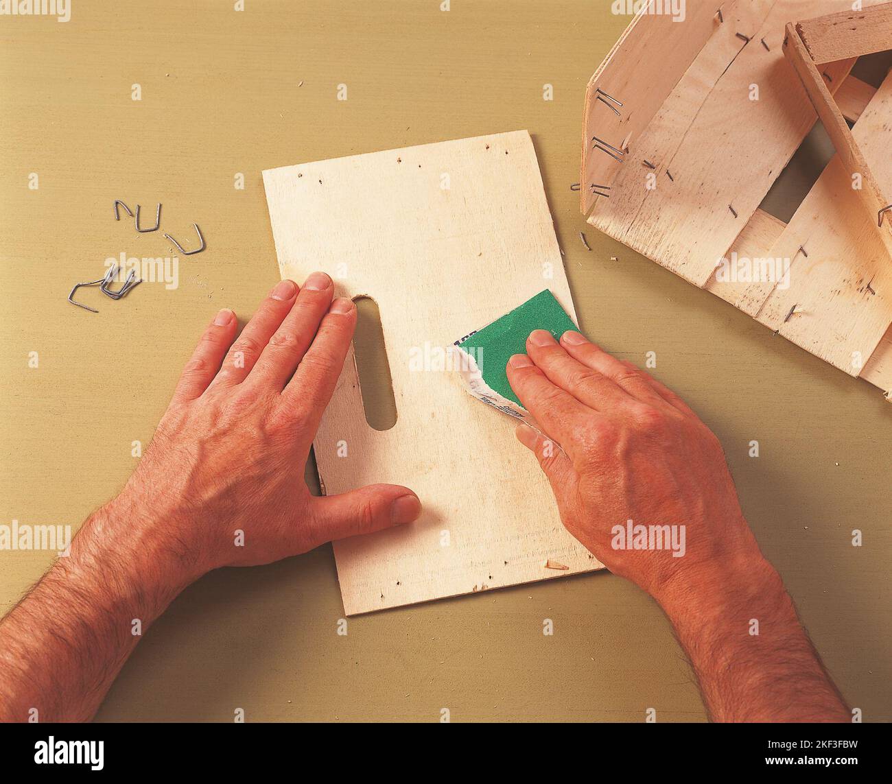 Sanding one side of fruit box with sanding paper Stock Photo - Alamy