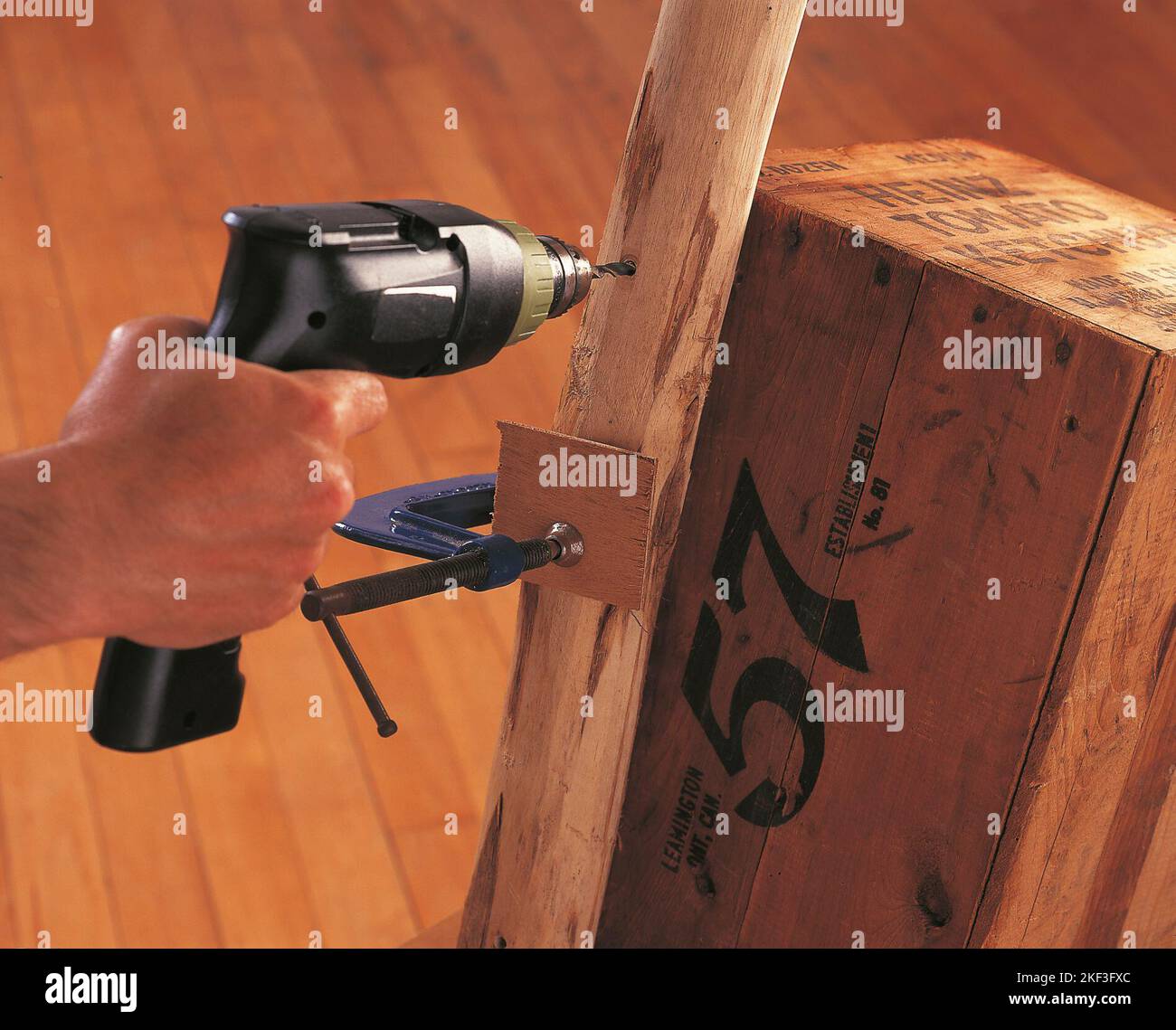 Drilling a hole through the leg and the box Stock Photo - Alamy