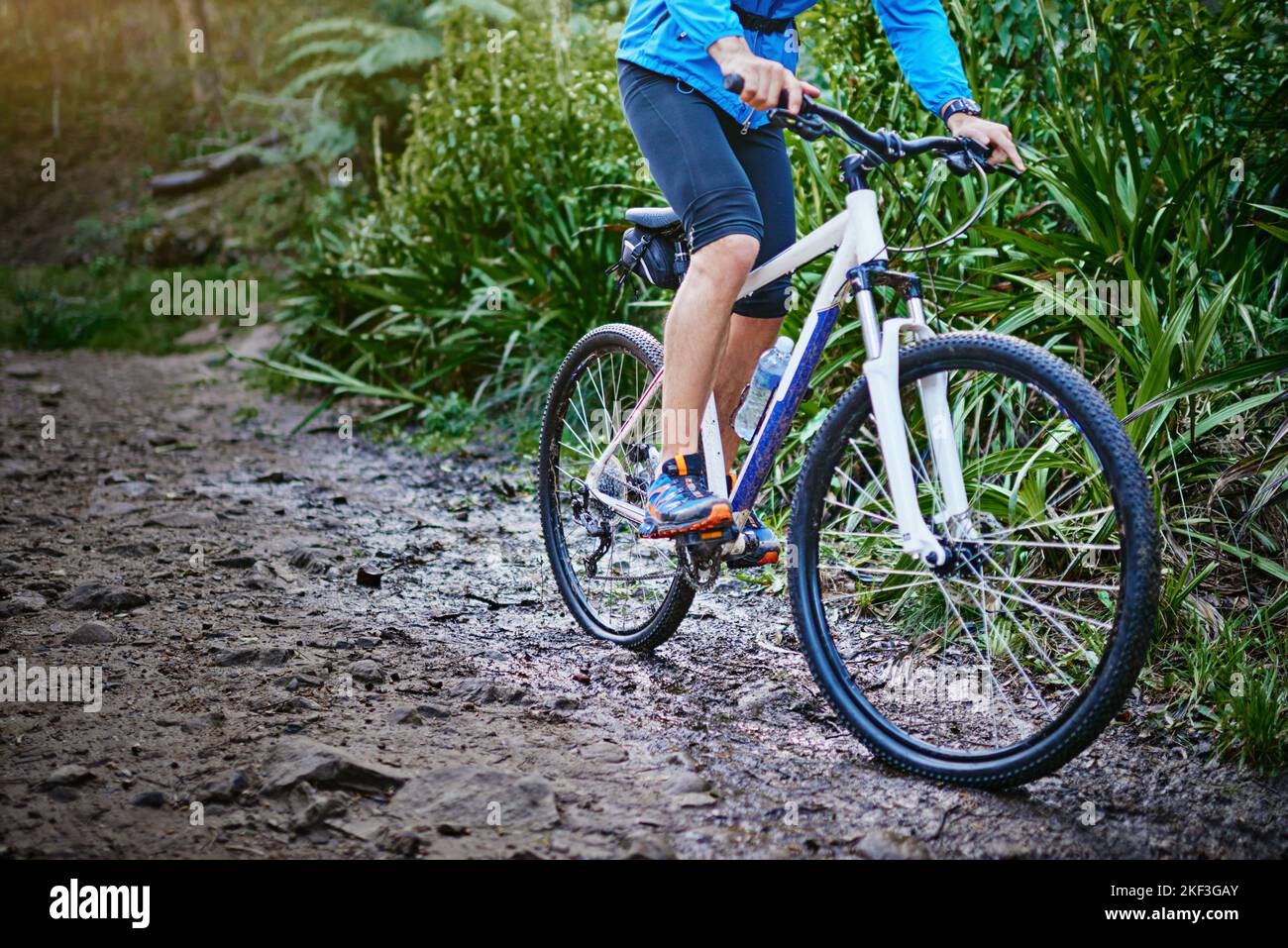 Powering down the trail. a male cyclist riding along a mountain bike ...