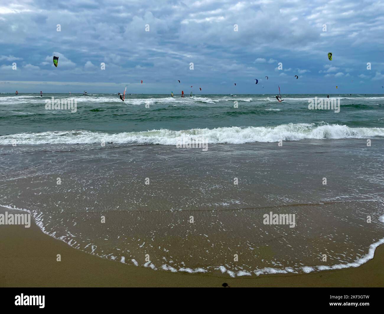 Surfer and Kite Surfer on a windy and sunny day at north sea beach ...