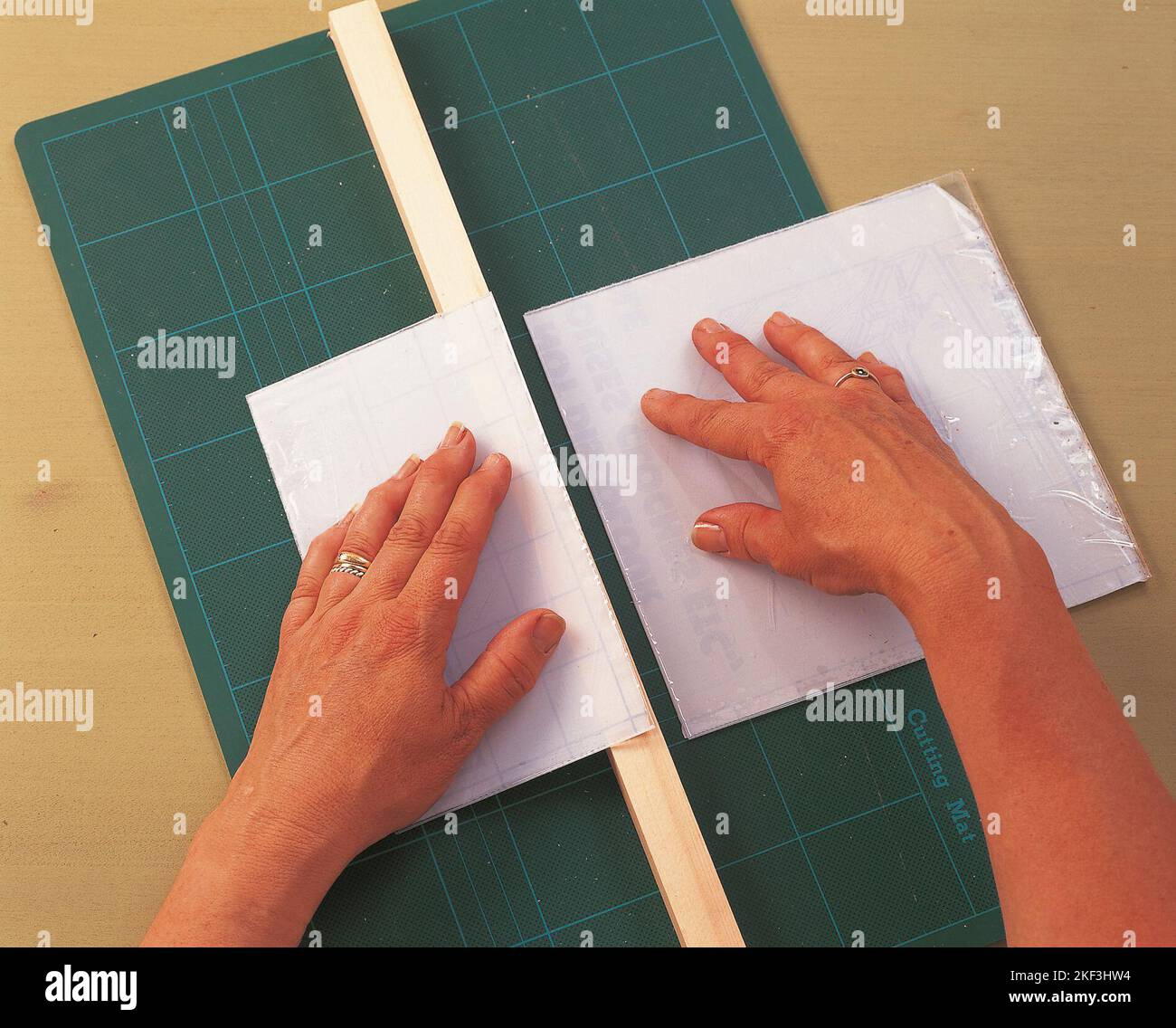 Dividing the perspex along the scored line Stock Photo - Alamy