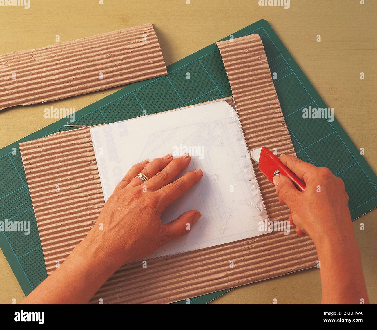 Cutting out a square of the cardboard Stock Photo - Alamy