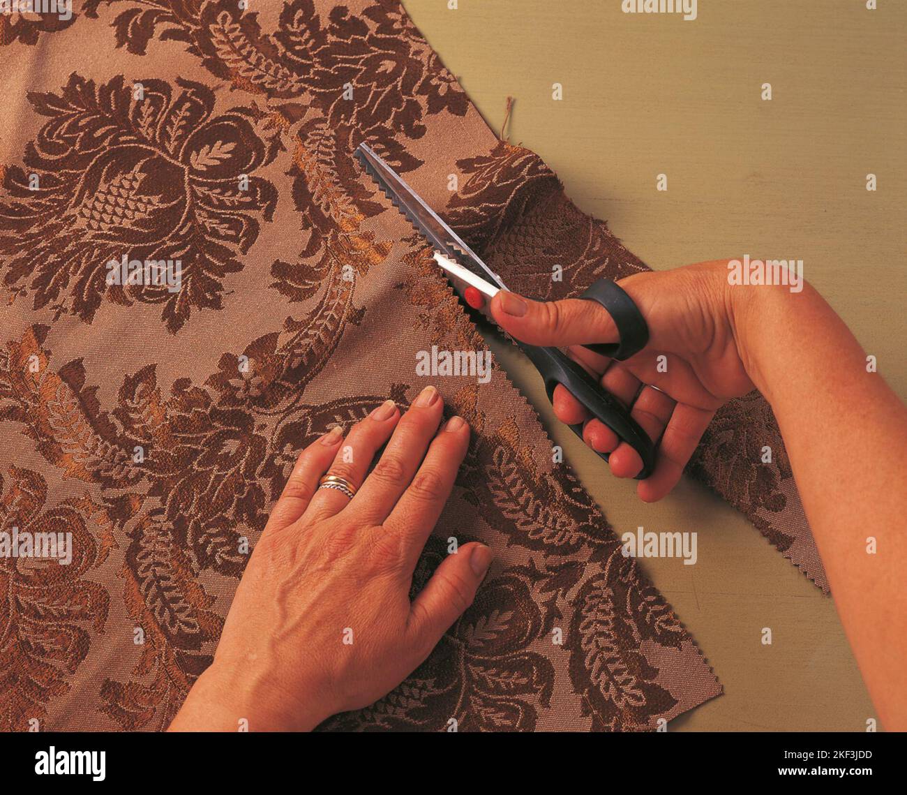Cutting fabric with pinking shears Stock Photo - Alamy
