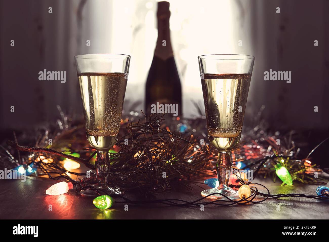 Two Glasses with champagne and bottle on a wooden table decorated with ...