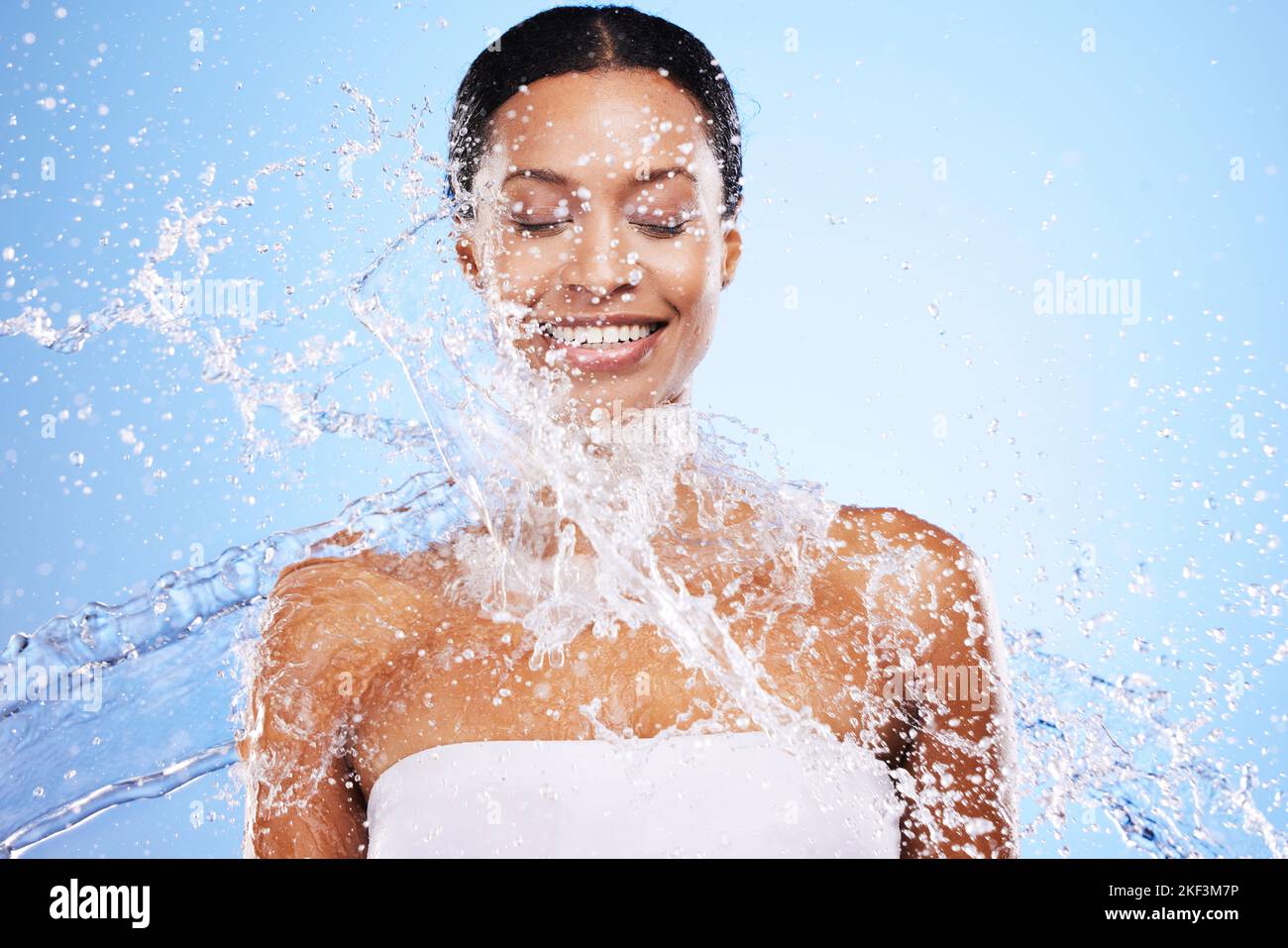 Water splash, black woman and beauty on blue background, skincare ...