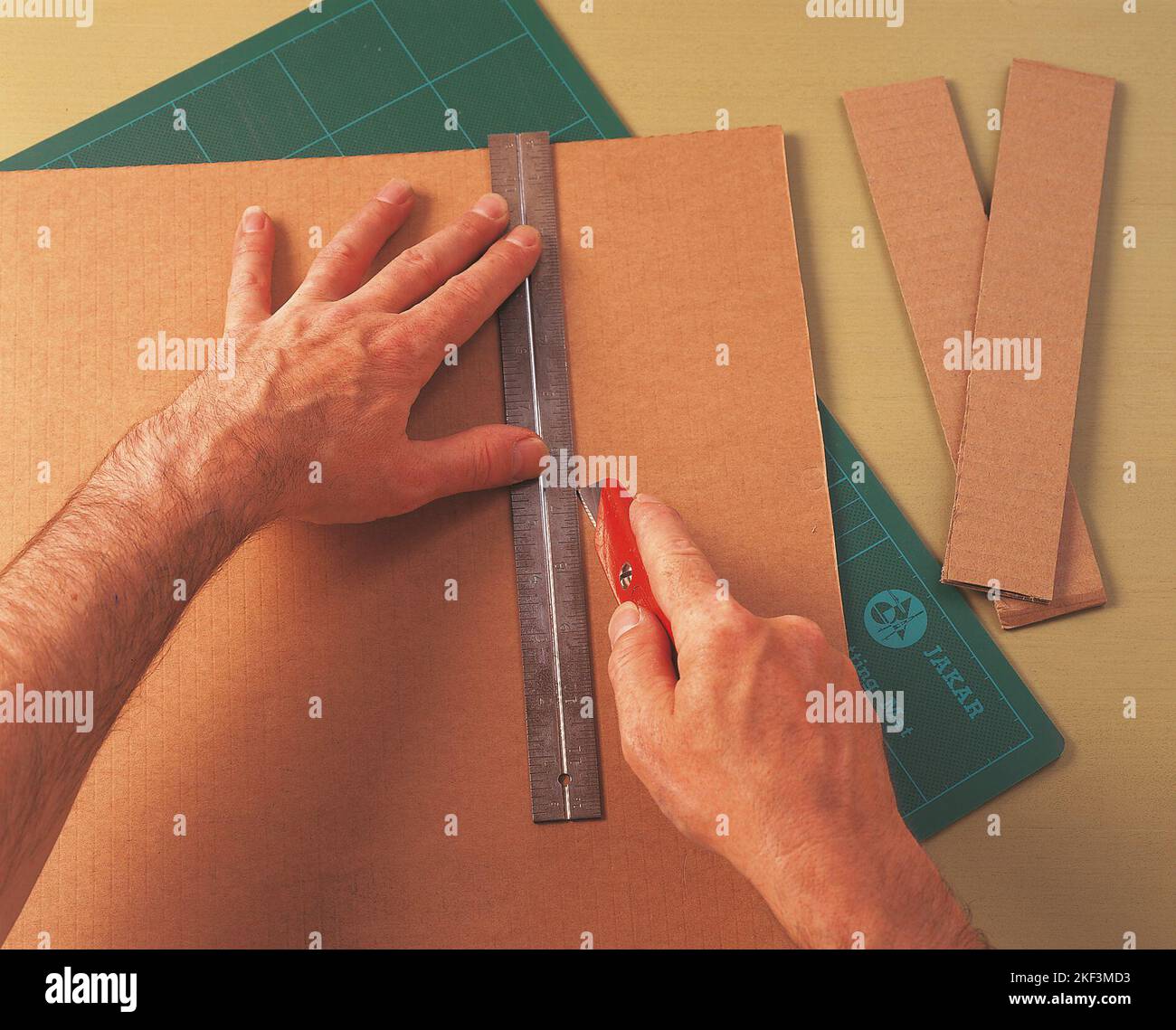 Cutting corrugated cardboard with craft knife and metal ruler Stock ...