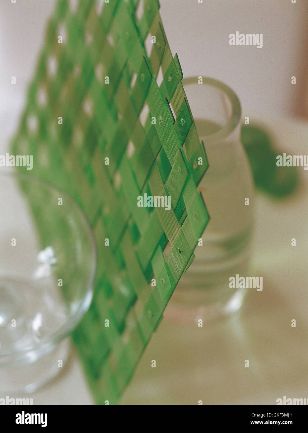 Woven plastic mat positioned between glass containers Stock Photo - Alamy