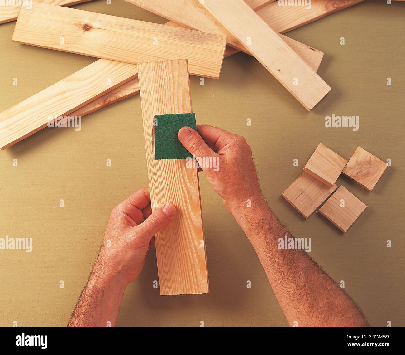 Smoothing the surface of a piece of timber with sandpaper Stock Photo ...