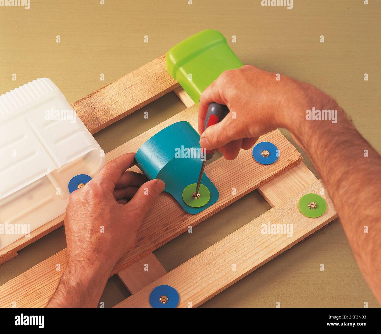 Attaching a small plastic container to the wooden frame Stock Photo - Alamy