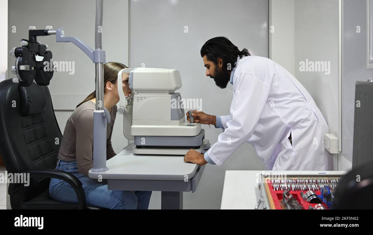 Indian male ophthalmologist checking eyesight female patient with auto ... Indian male ophthalmologist checking eyesight female patient with auto ...