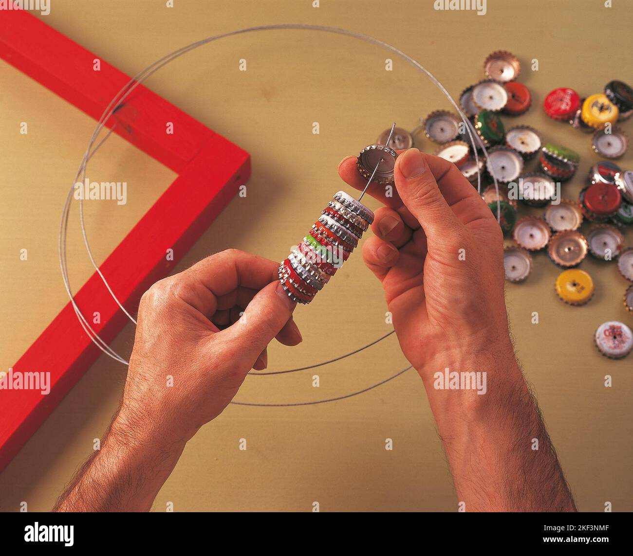Threading the pierced caps onto the wire Stock Photo - Alamy