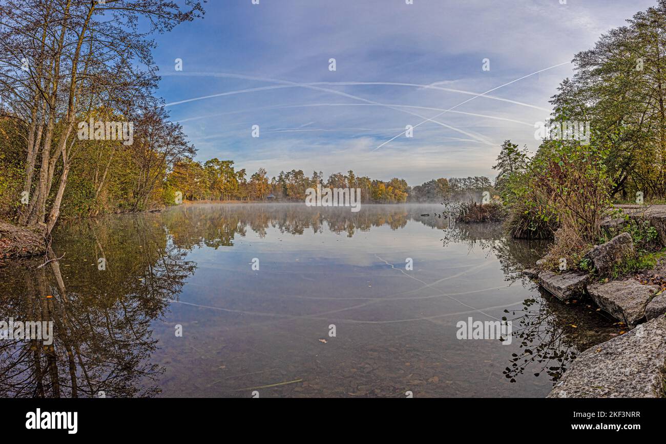 Panoramic image over pond during sunrise in autumn with early morning ...